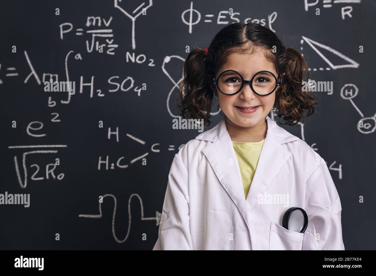cheerful little girl science student with glasses in lab coat smiles on ...