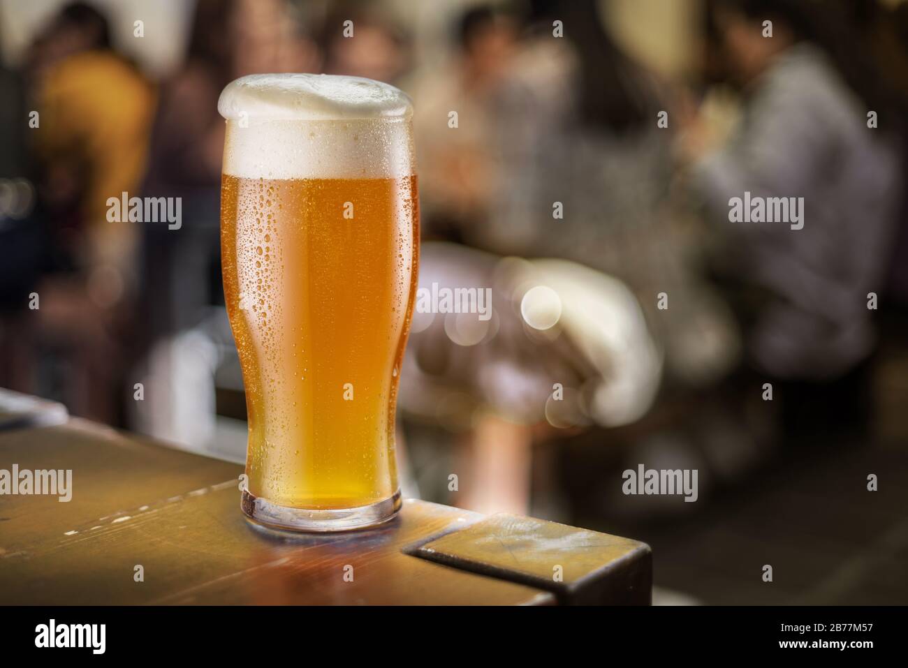 Glass of beer stands on a table in a pub. White unfiltered beer Stock ...