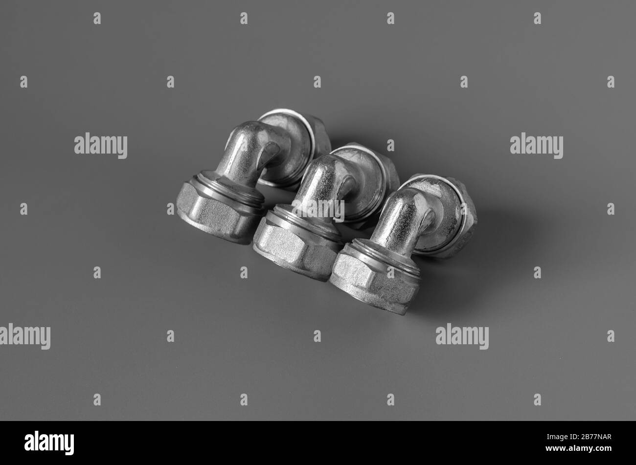 Corner fitting for multilayer pipes. Three assembled fittings on a gray ...