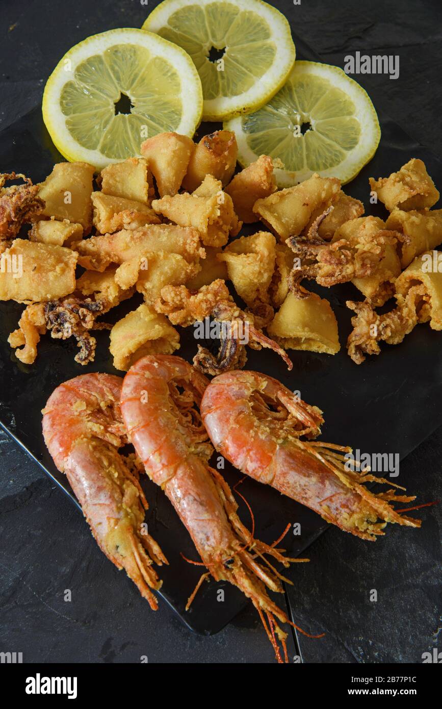 Fish fry with lemon on black stone sieve - Vertical studio shot Stock ...