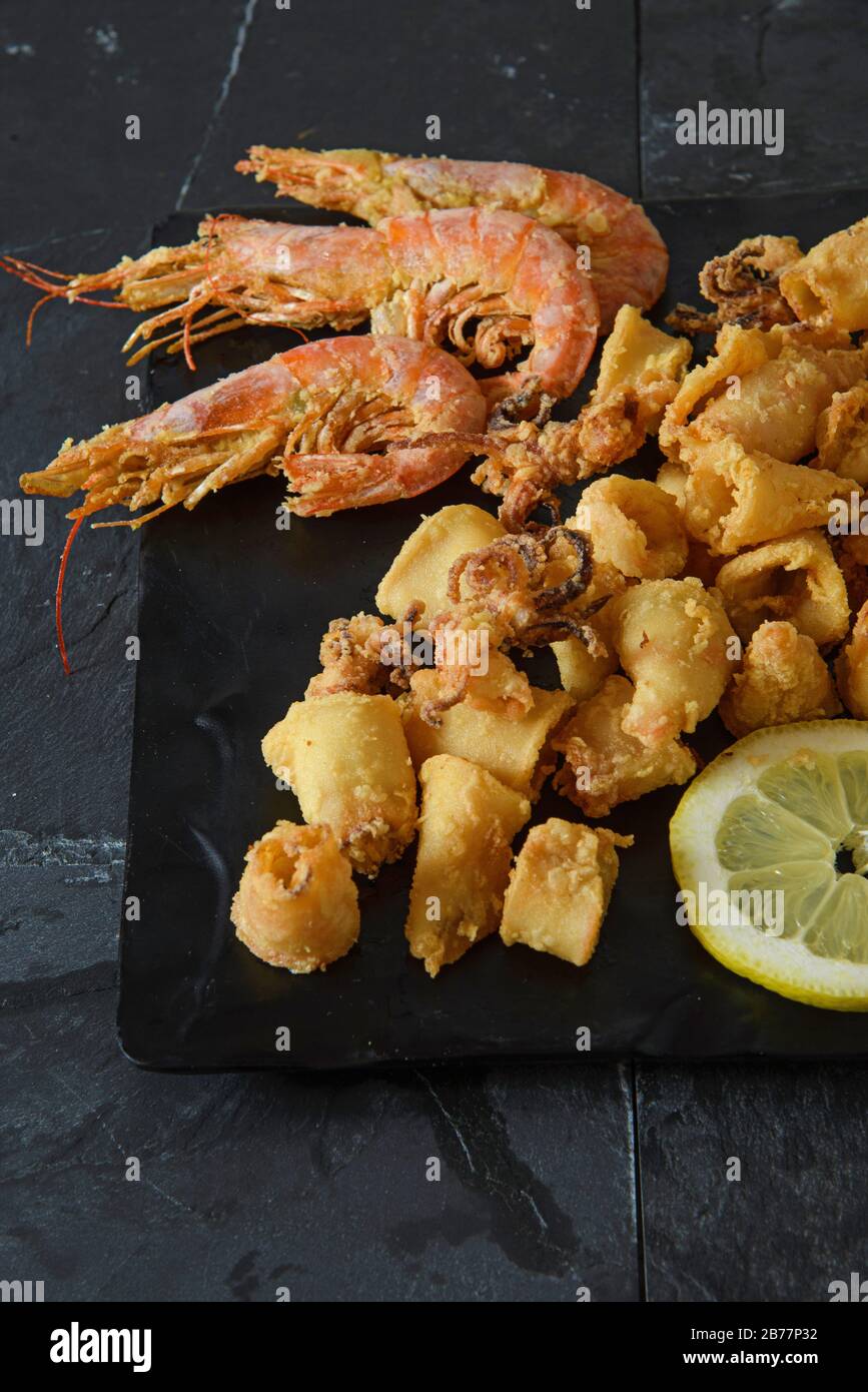 Fish fry with lemon on black stone sieve - Vertical studio shot Stock ...