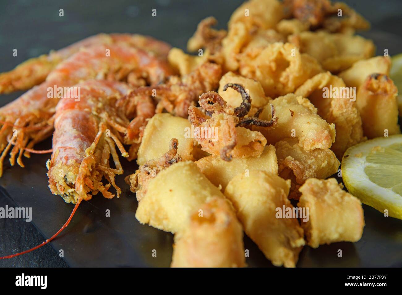 Fish fry with lemon on black stone sieve - Hotizontal studio shot Stock ...
