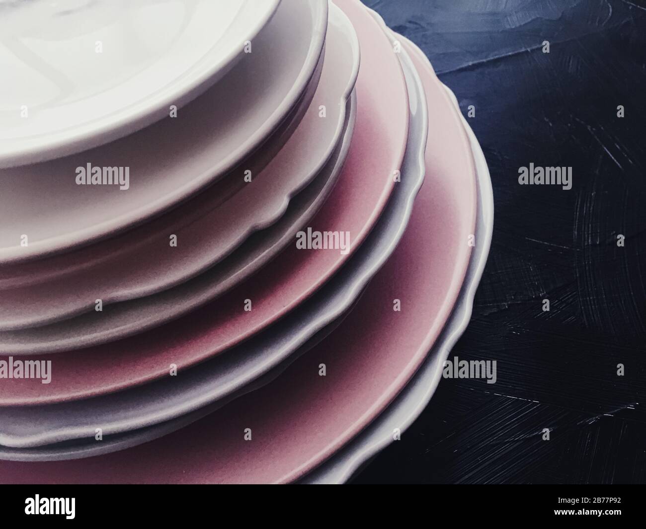 Stack of clean empty plates on black background, luxe dishware and ...