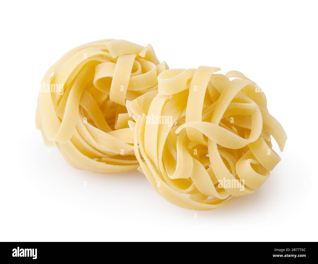 Uncooked nests of tagliatelle pasta isolated on white background with ...