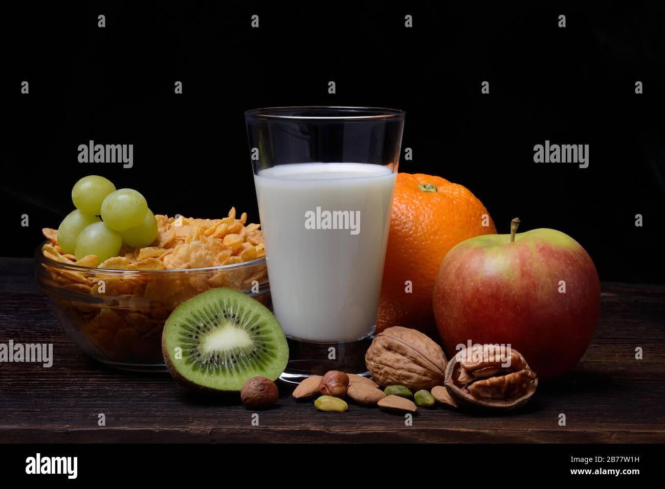 A glass of milk, bowl with cornflakes, fruits and nuts, Germany Stock ...