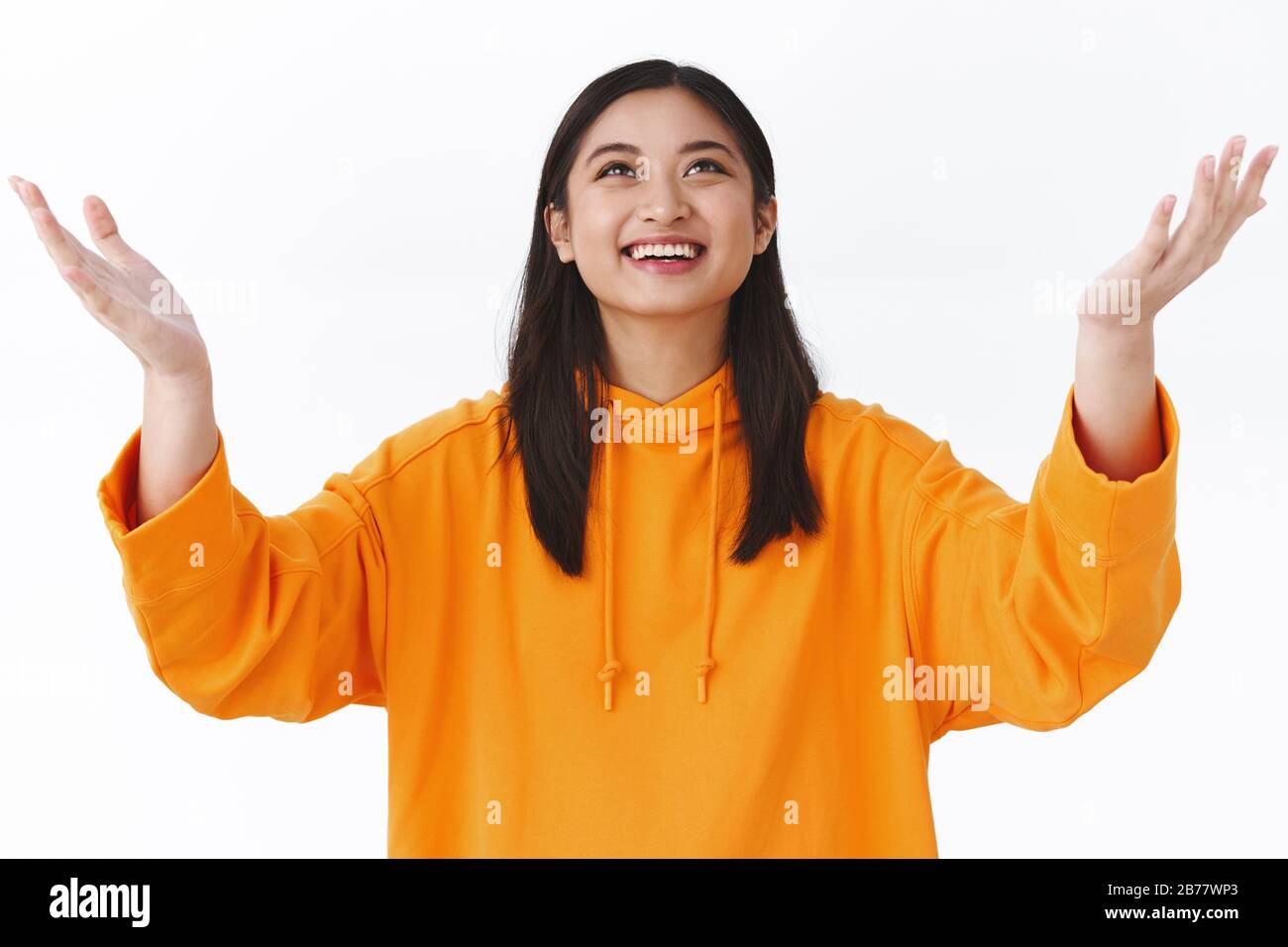Girl catching something from sky. Cheerful happy asian woman raising ...