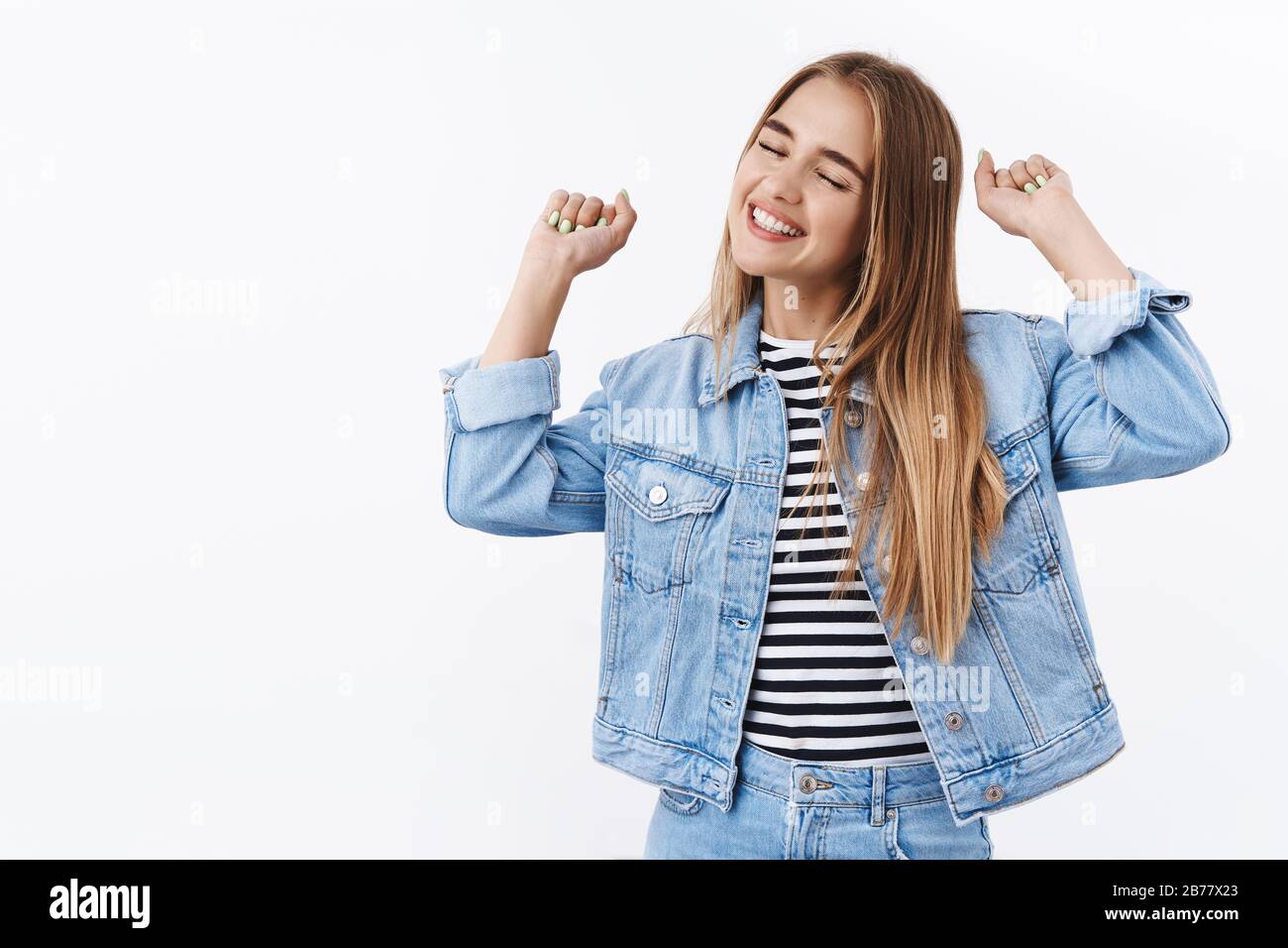 Happy and pleased cheerful blond girl celebrating victory, smiling ...