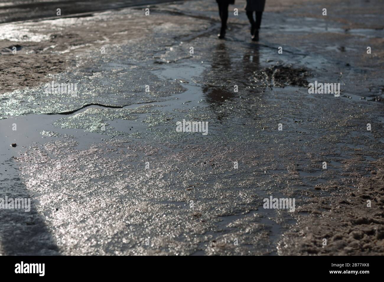 Spring puddles, snowdrifts, snow, mud and melted dirty water on ...