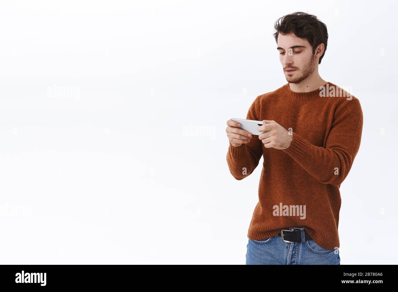 Attractive european guy using mobile phone, hold smartphone ...