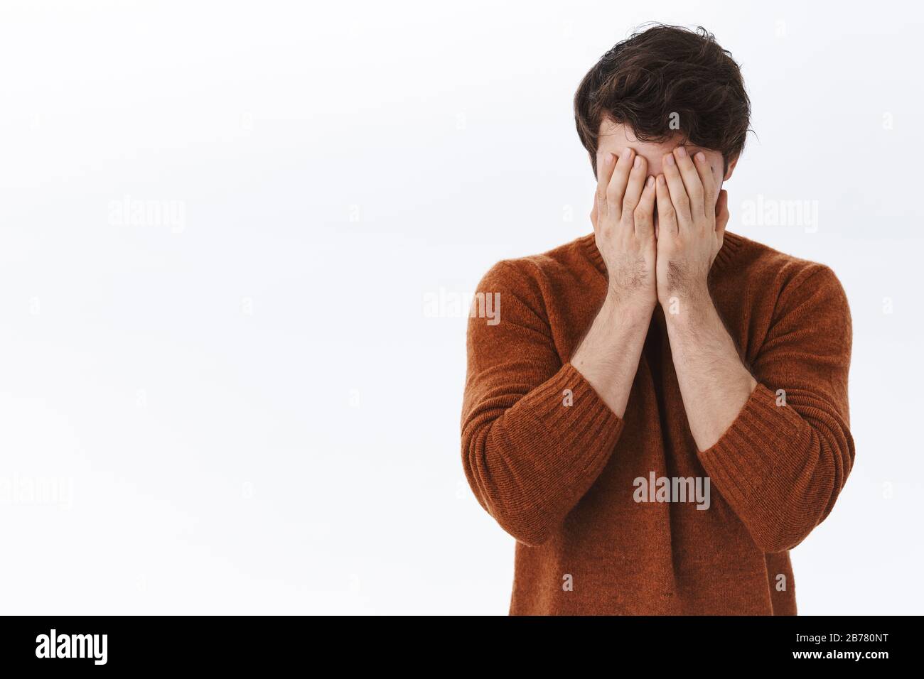 Hopeless and desperate young tired man in sweatshirt, cover face with ...