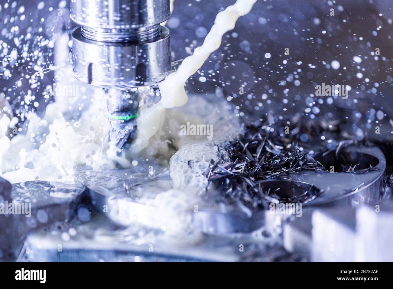 Close-up view of vertical cnc steel milling process with external water ...