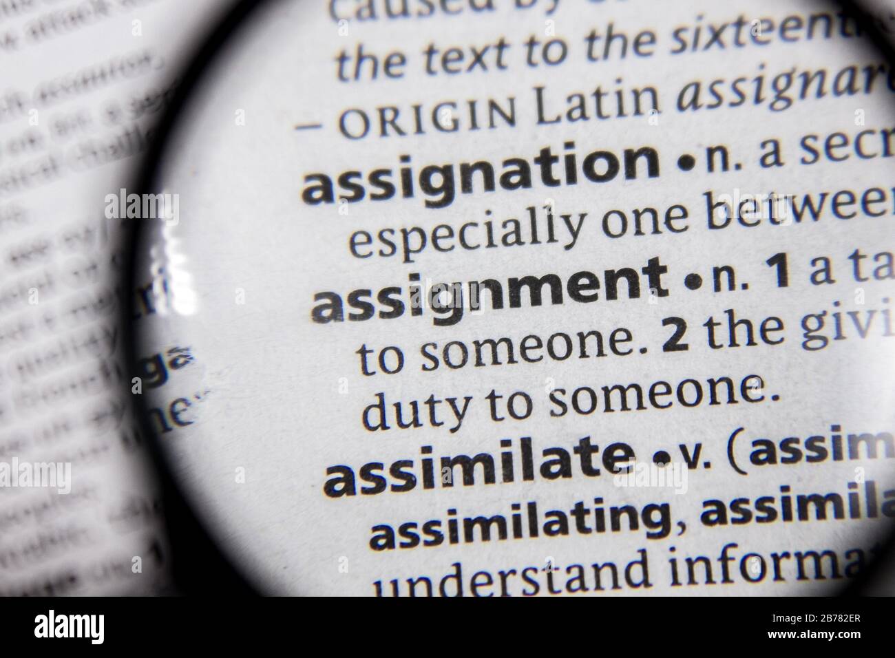 The word or phrase assignment in a dictionary book Stock Photo - Alamy