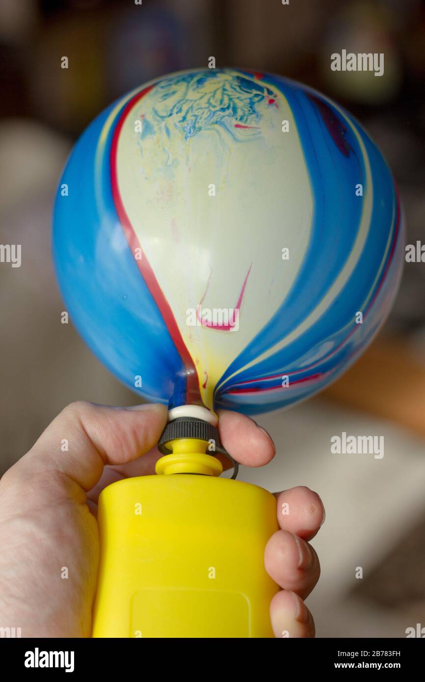 Inflating a balloon with the yellow pump Stock Photo - Alamy
