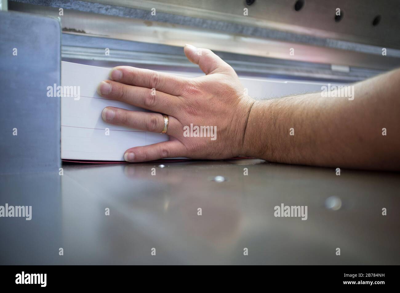 hand pushing a ream of paper on a industrial knife cutter Stock Photo ...