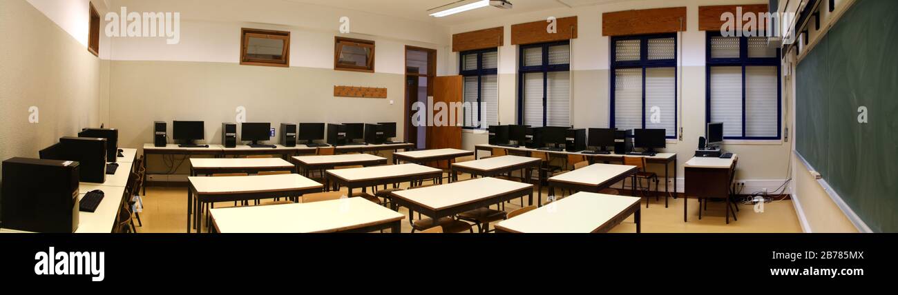 View of the interior of a classroom with row of computers on middle ...