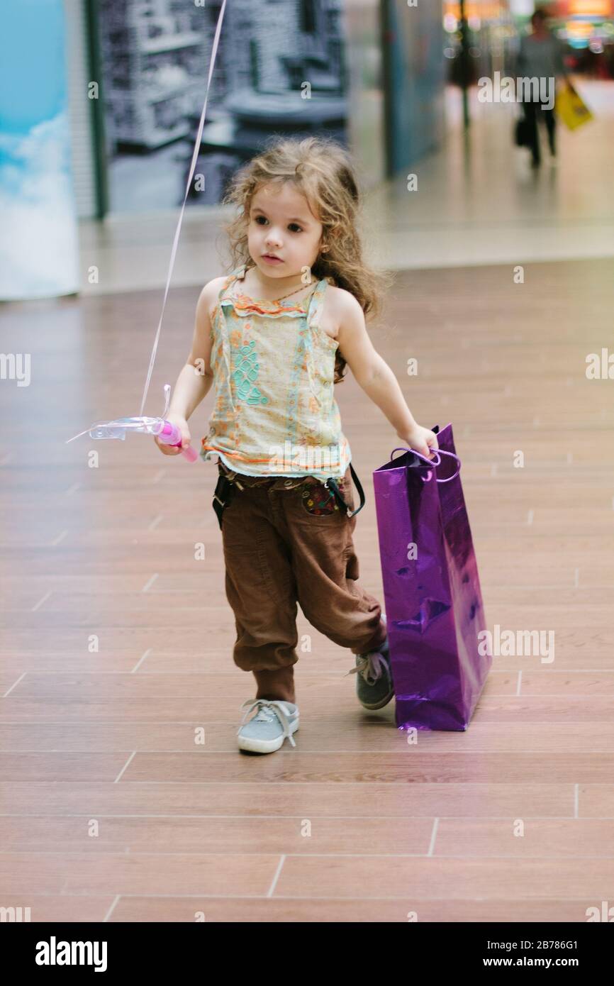 Little kid girl walking on a mall with shopping bag Stock Photo - Alamy