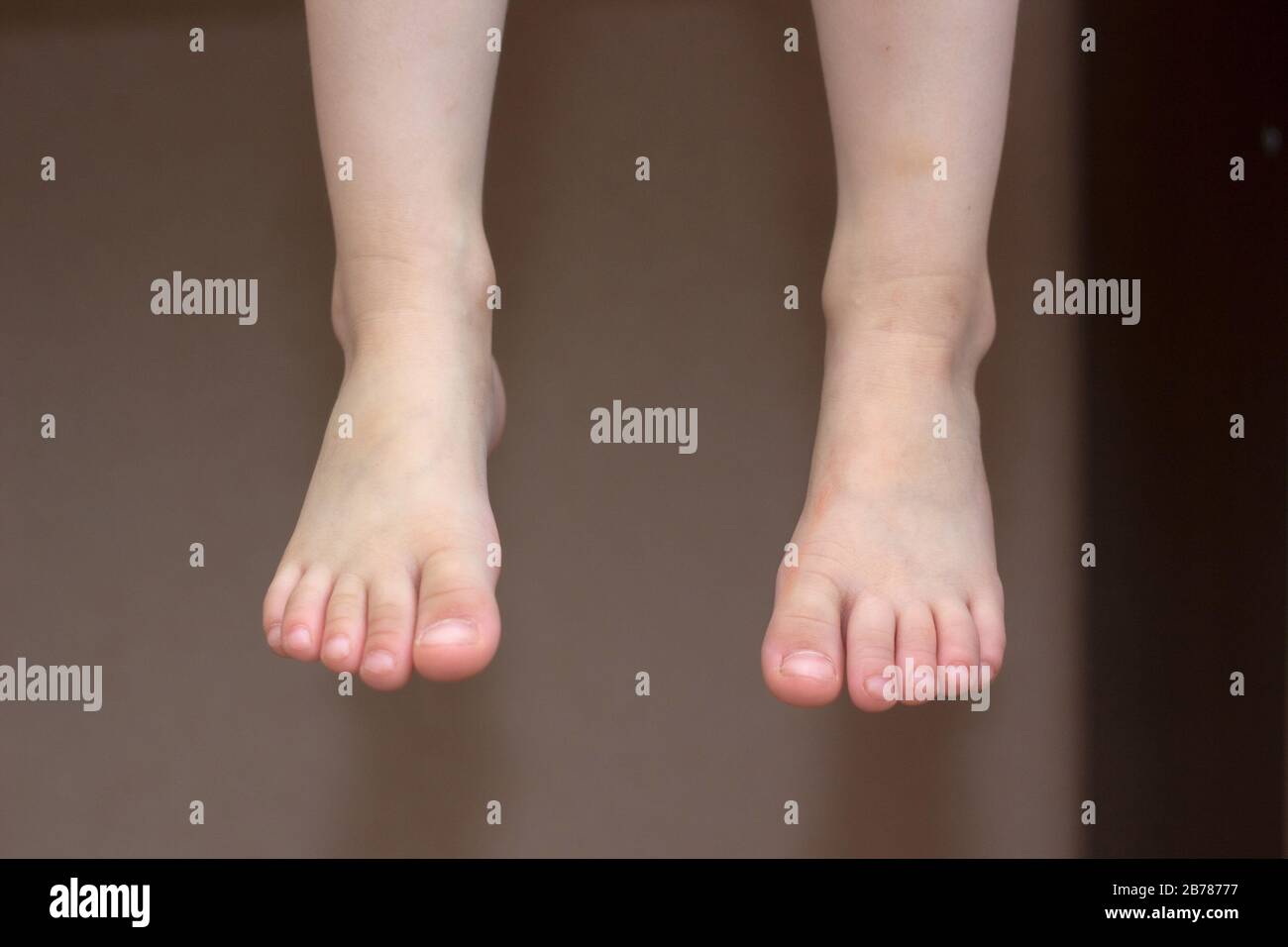 Baby feet. Kid toes while kid sitting on the chair Stock Photo - Alamy