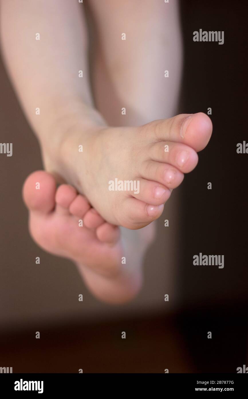 Baby feet. Kid toes while kid sitting on the chair Stock Photo - Alamy