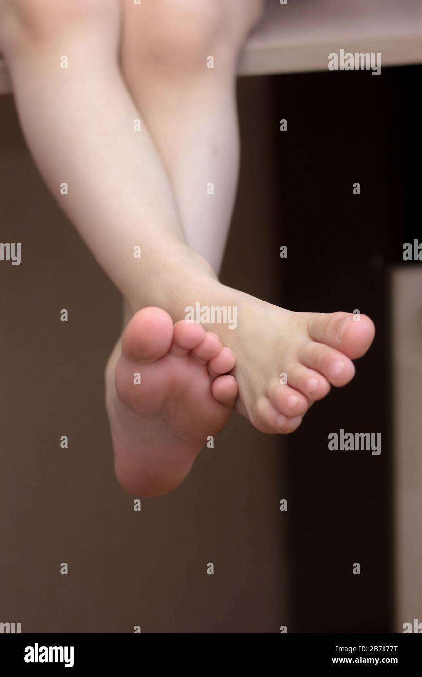 Baby feet. Kid toes while kid sitting on the chair Stock Photo - Alamy