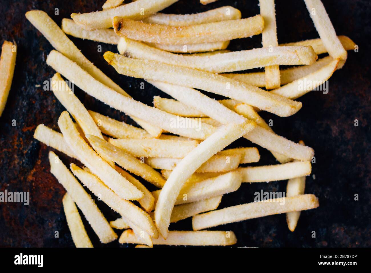 Lot of frozen potatoes fry on black rust background Stock Photo - Alamy