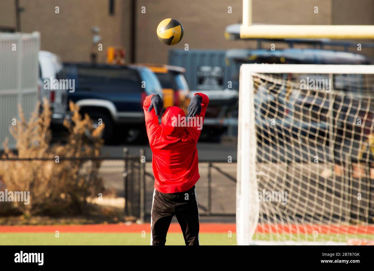 A track and field athlete throws a medicine ball backwards during ...