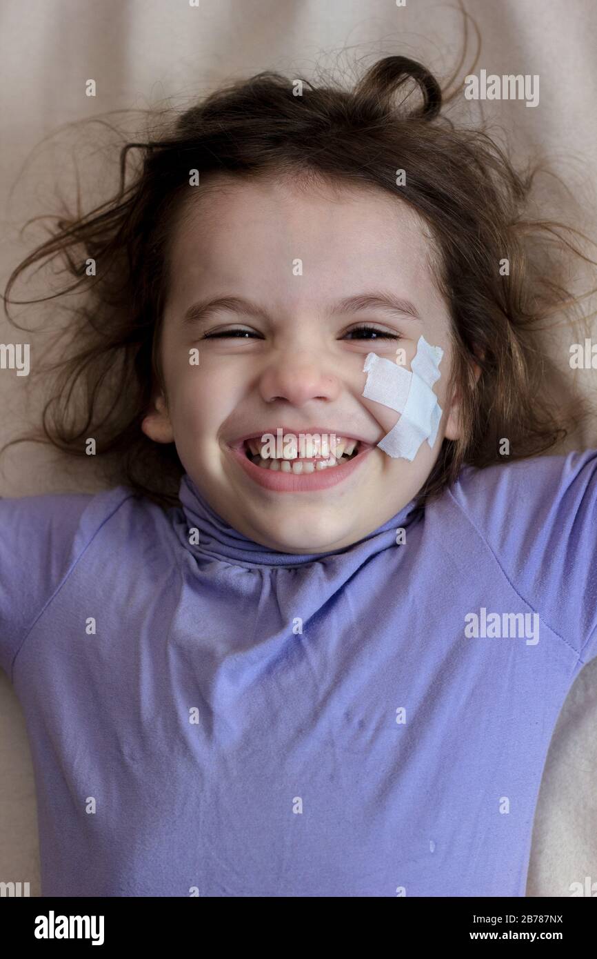 Little kid girl after accident with adhesive band on face laughing ...