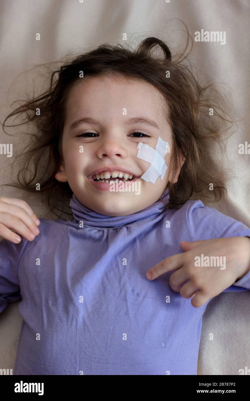 Little kid girl after accident with adhesive band on face laughing ...