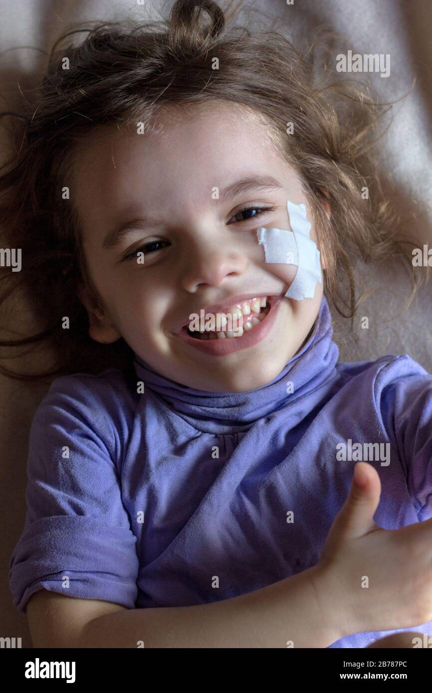 Little kid girl after accident with adhesive band on face laughing ...
