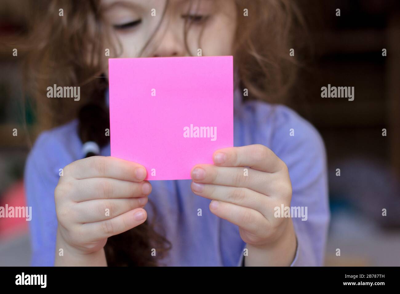 Young kid girl with color paper sticker in hands Stock Photo - Alamy