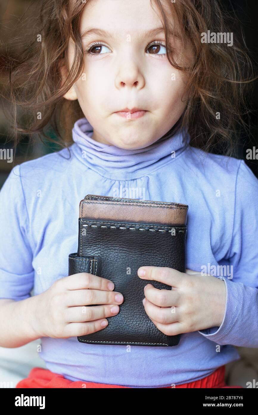 Little kid girl holds wallet in hands Stock Photo - Alamy