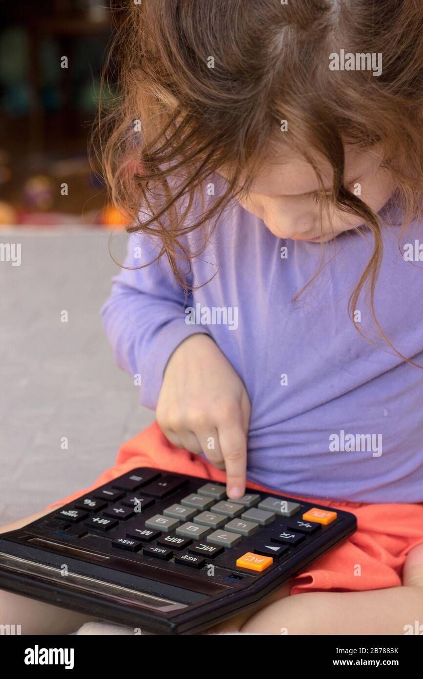 Little kid girl with a calculator in hands Stock Photo - Alamy