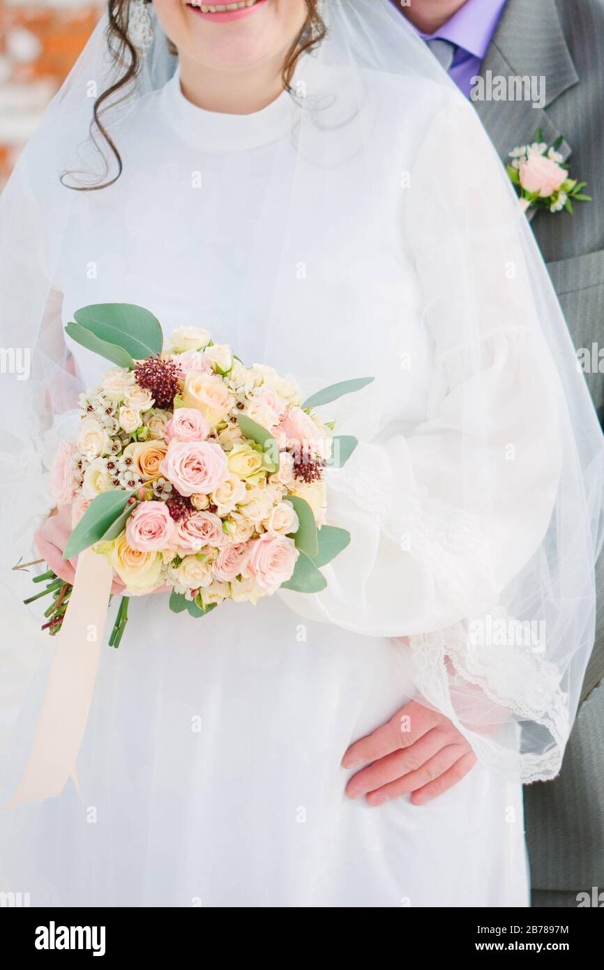 Bride and groom holding wedding bouquet outside Stock Photo - Alamy
