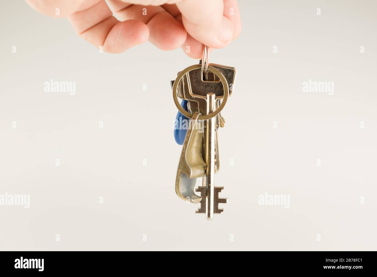 big bunch of different keys in hand isolated on a white background ...