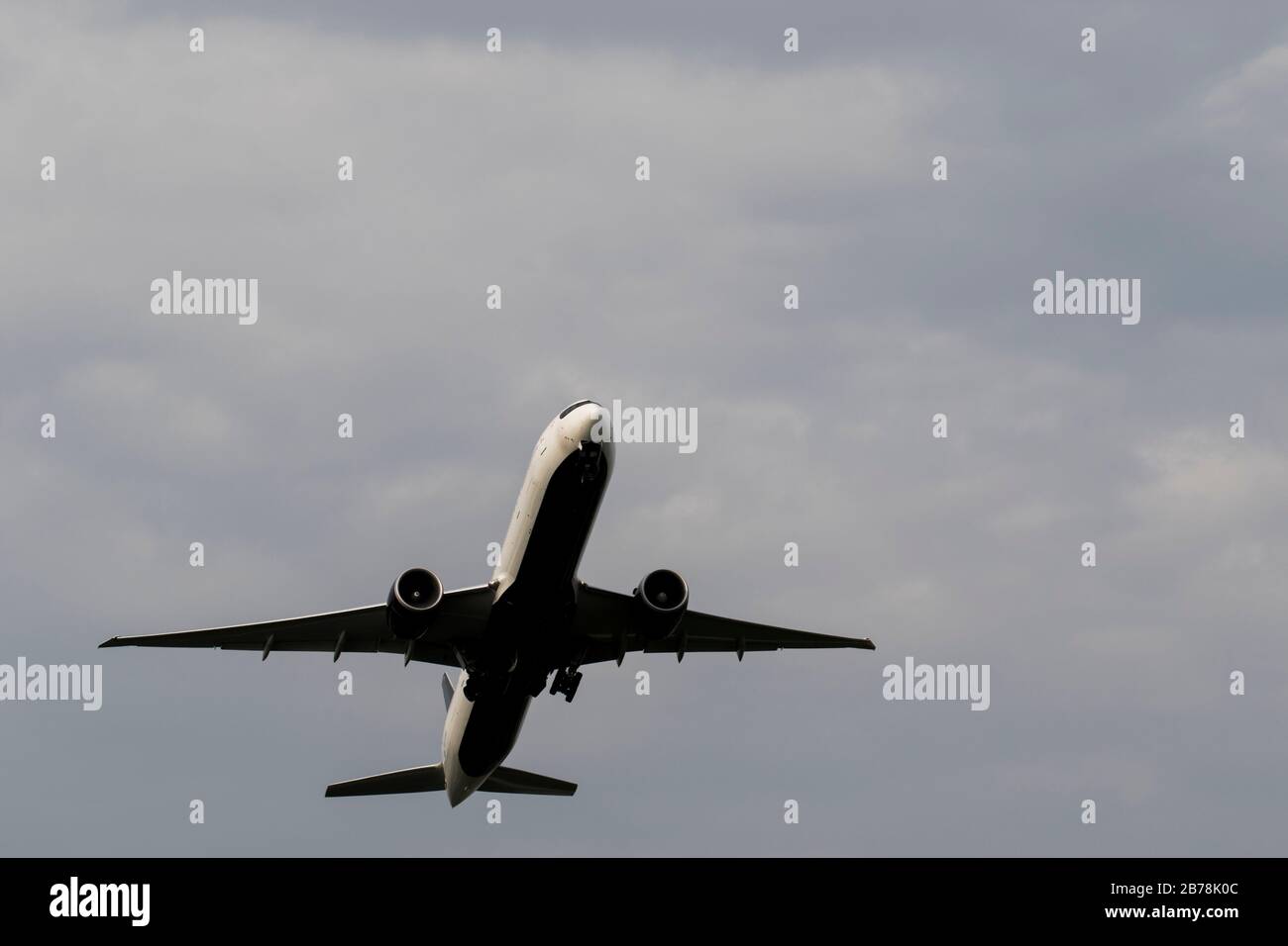 Airplane flying through the cloudy sky. Soaring plane in silhouette ...