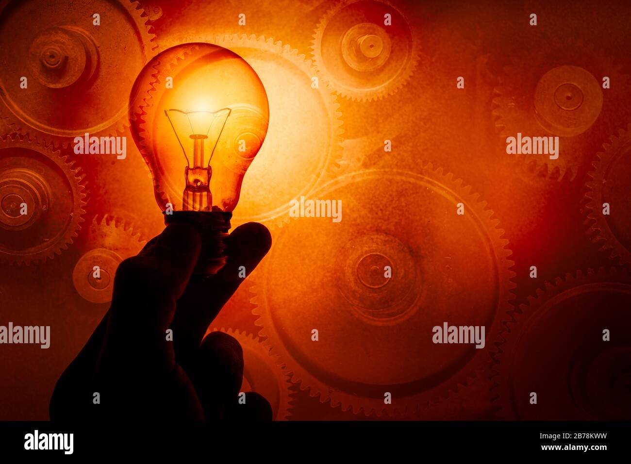 hand light bulb with gear wheel overlay for background. idea and ...