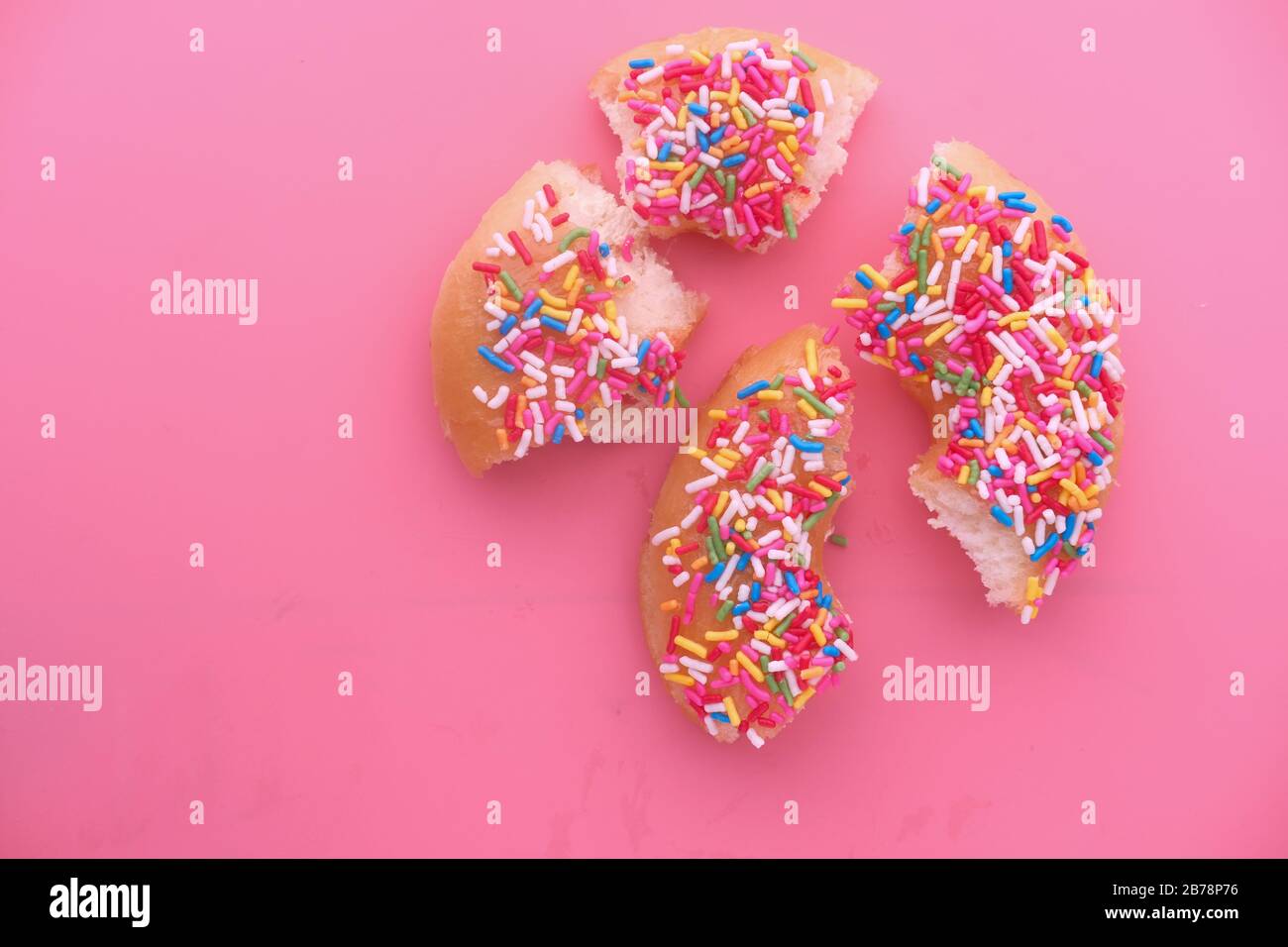 Donut shape made of cut donut slices on pink background Stock Photo - Alamy