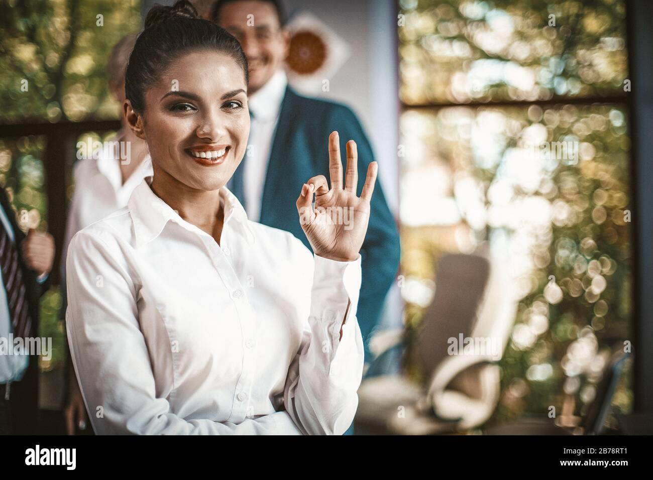 Smilling Business, Woman Shows Ok Sign In Office Stock Photo - Alamy