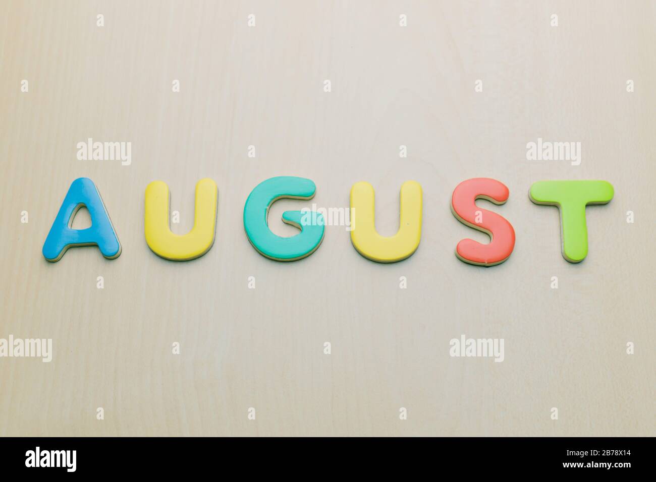 August word written with colorful letters on wooden background, top ...