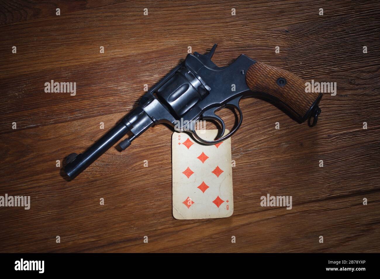 russian roulette - Eight of Diamonds plaing card and revolver with one ...