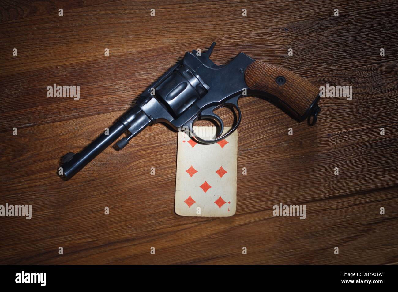 russian roulette - Seven of Diamonds plaing card and revolver with one ...