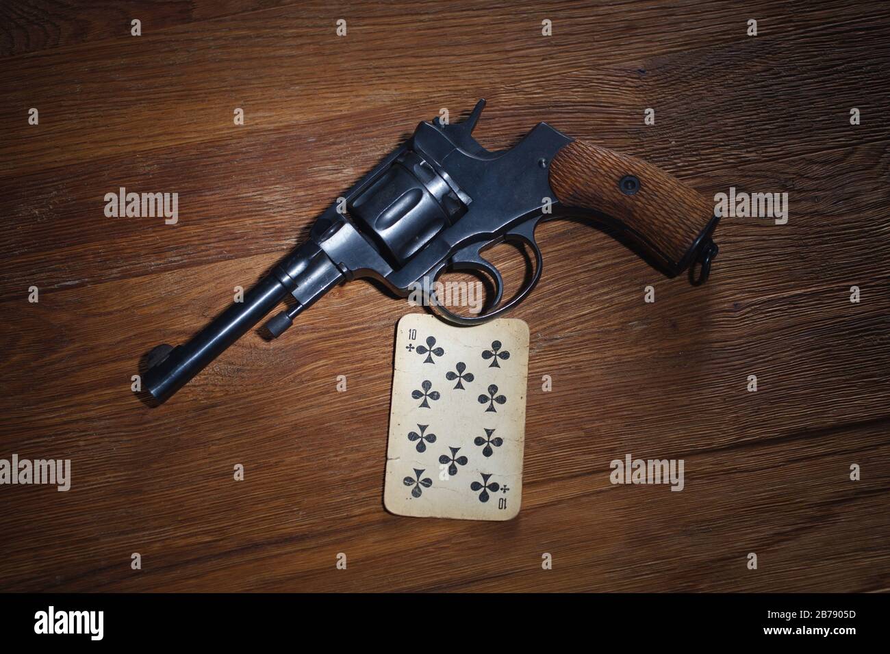 russian roulette - Ten of Clubs plaing card and revolver with one ...