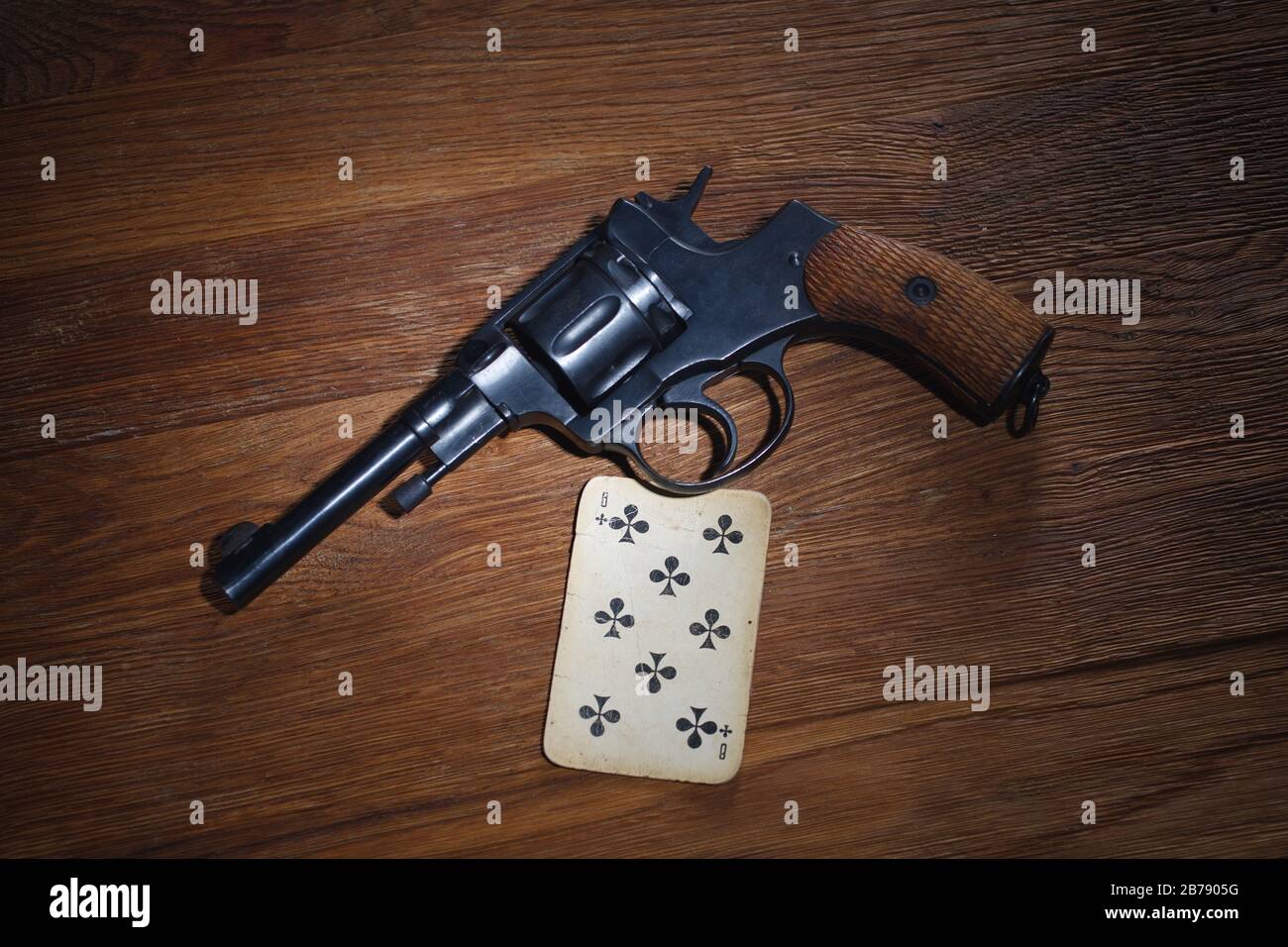 russian roulette - Eight of Clubs plaing card and revolver with one ...