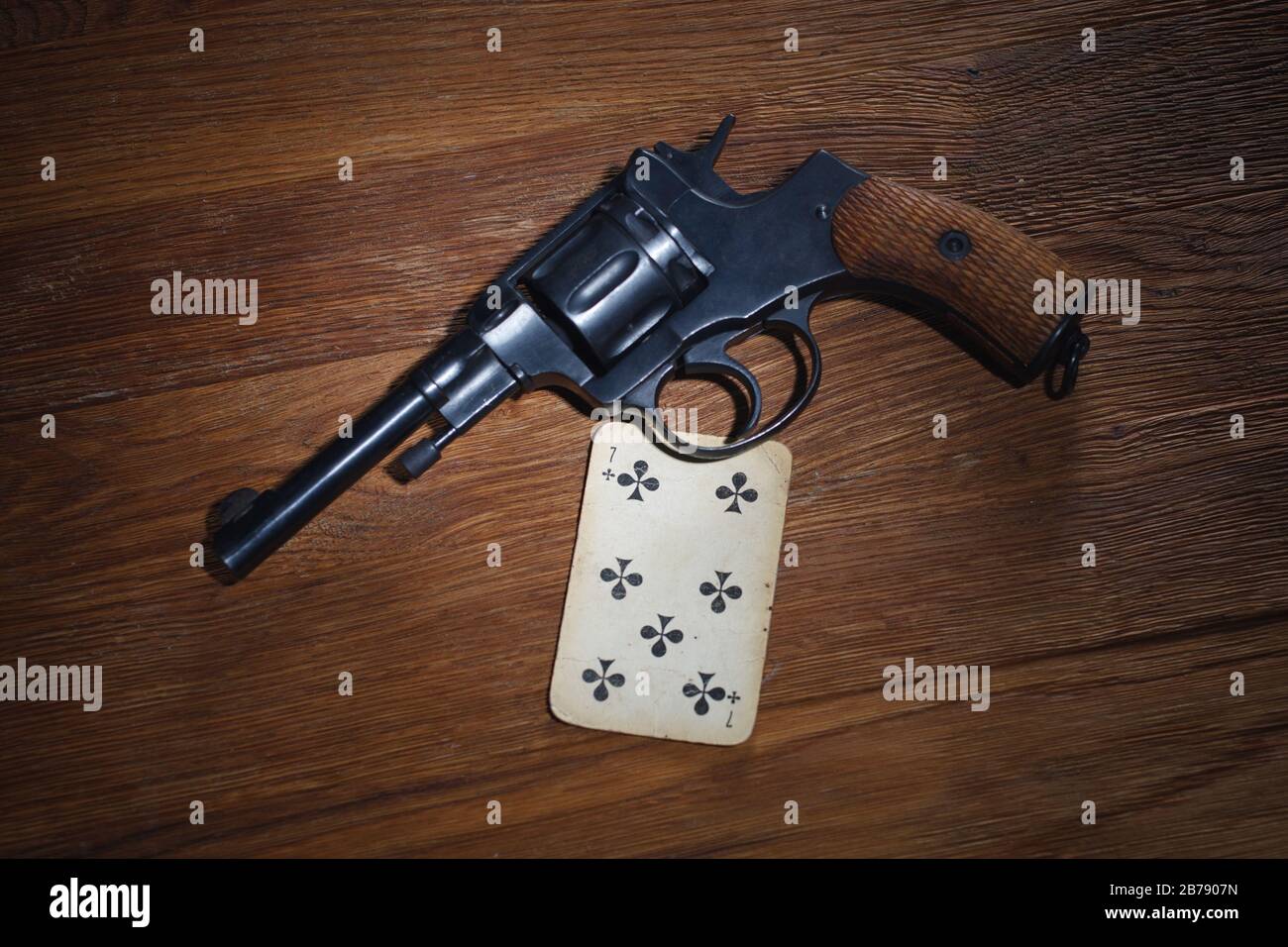 russian roulette - Seven of Clubs plaing card and revolver with one ...