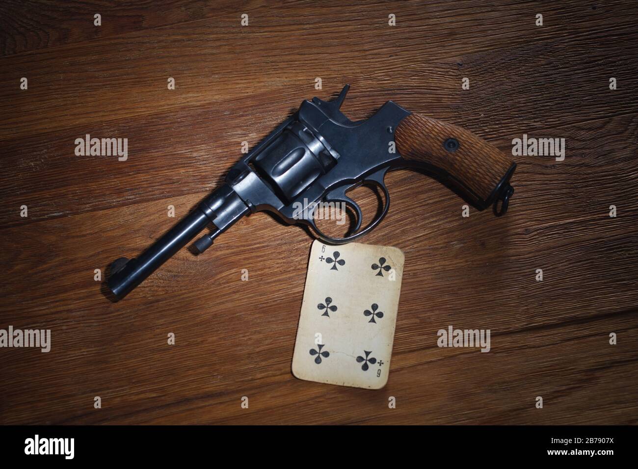 russian roulette - Six of Clubs plaing card and revolver with one ...