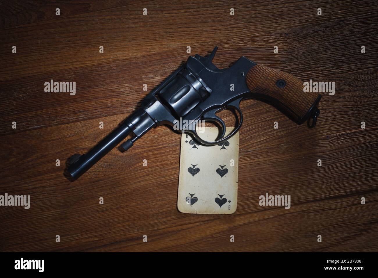 russian roulette - Six of Spades plaing card and revolver with one ...