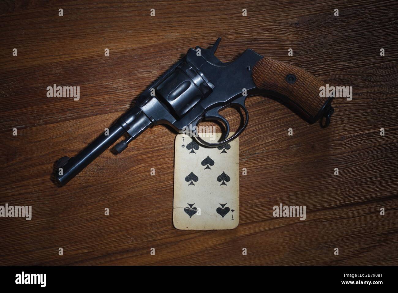 russian roulette - Seven of Spades plaing card and revolver with one ...