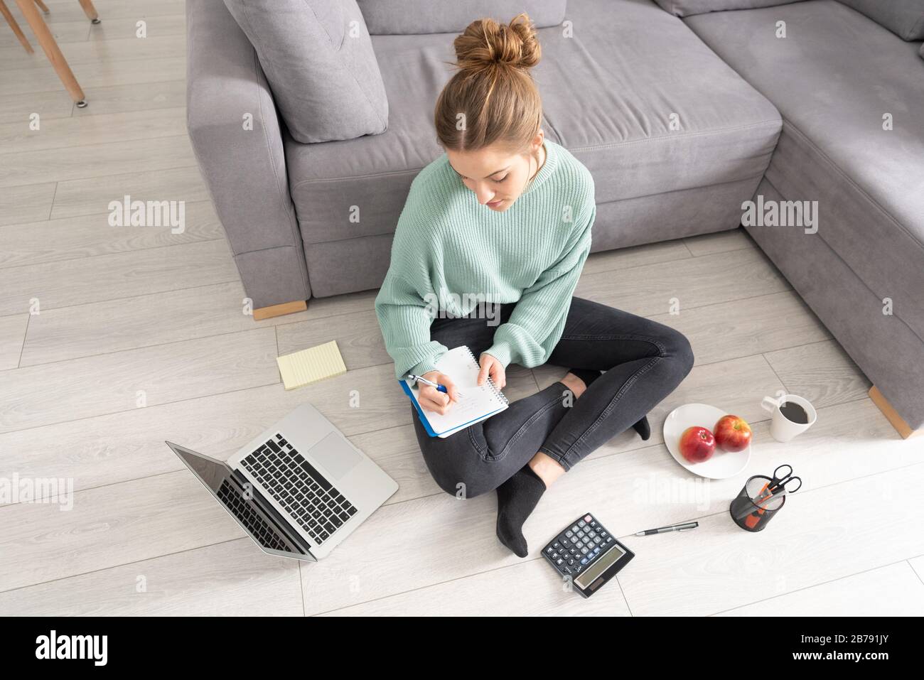 Young student learns at home on the floor. Studying, learning concept ...