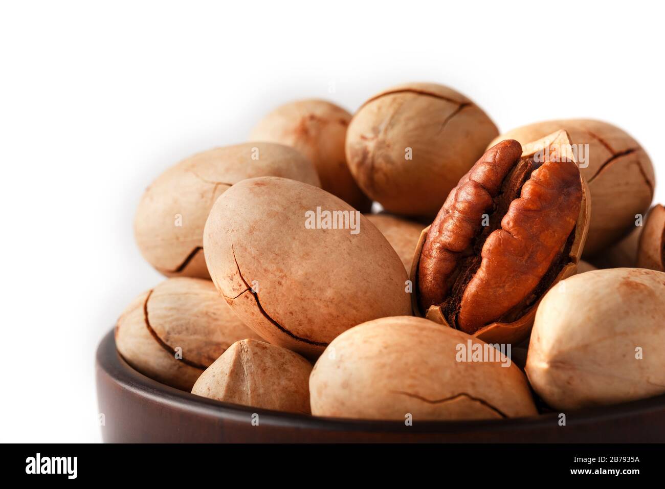 Pecan in a wooden Cup isolated on a white background. Isolate. A nut in ...