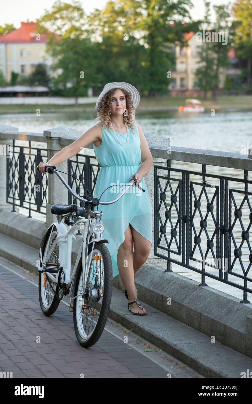 pretty woman biker with bicycle walking in park smiling Stock Photo - Alamy