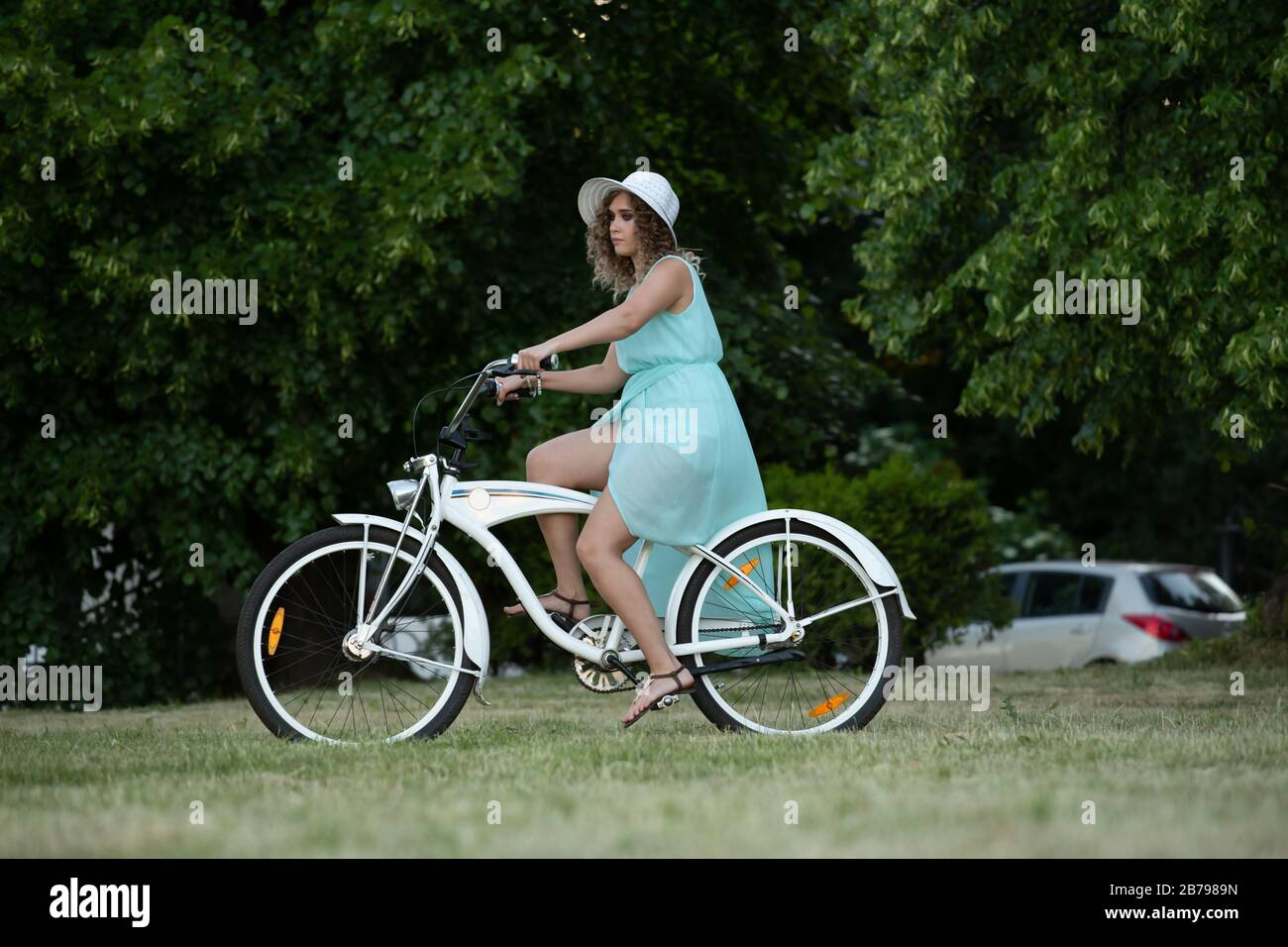 pretty woman biker on bicycle riding in park smiling Stock Photo - Alamy